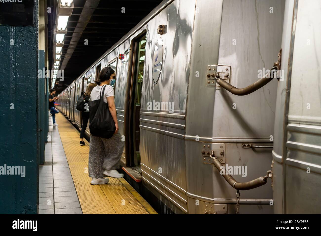 Riders on the subway in New York on the first day the city reopens for ...