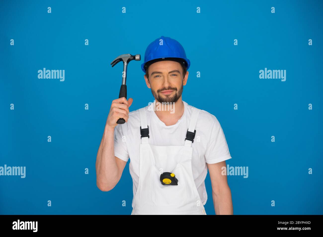 Smiling workman holding up a hammer Stock Photo - Alamy