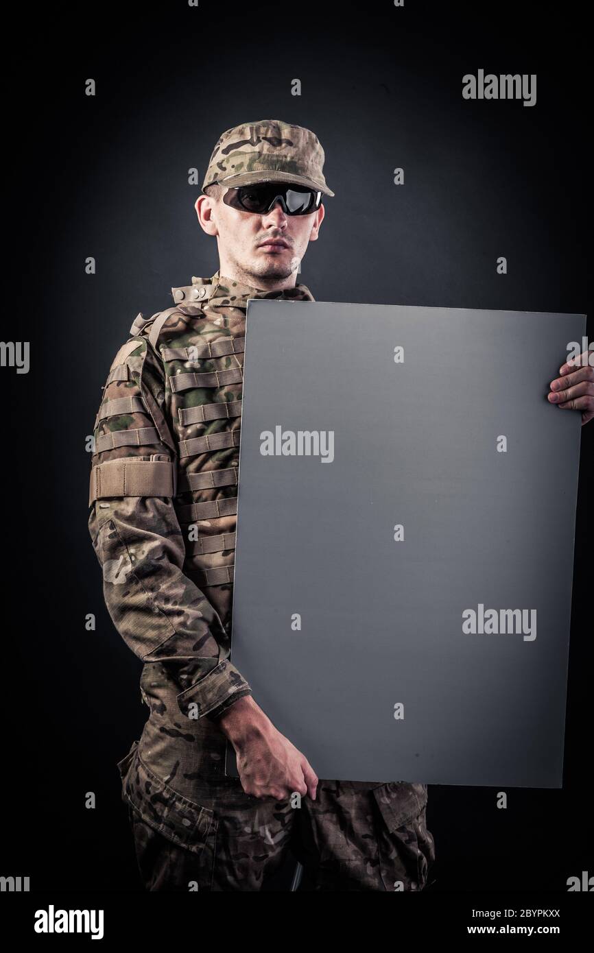 Modern soldier is holding a poster Stock Photo - Alamy
