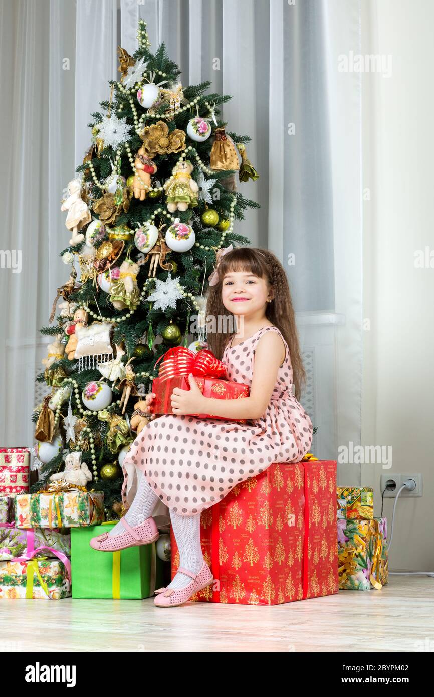 Happy little girl with christmas present smiling Stock Photo - Alamy