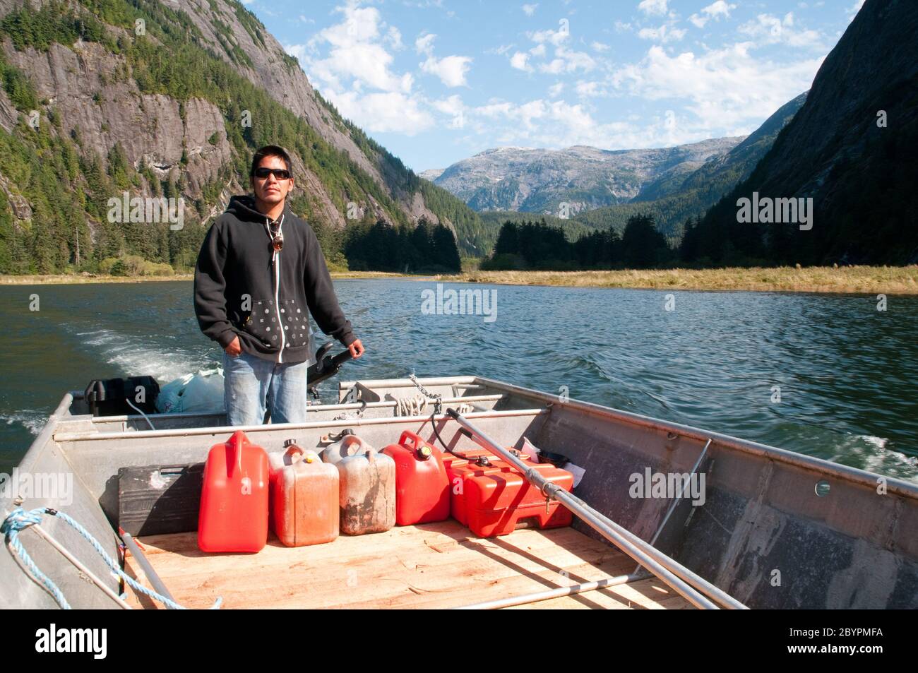 An indigenous man drives an aluminum punt at the head of Mussel Inlet ...