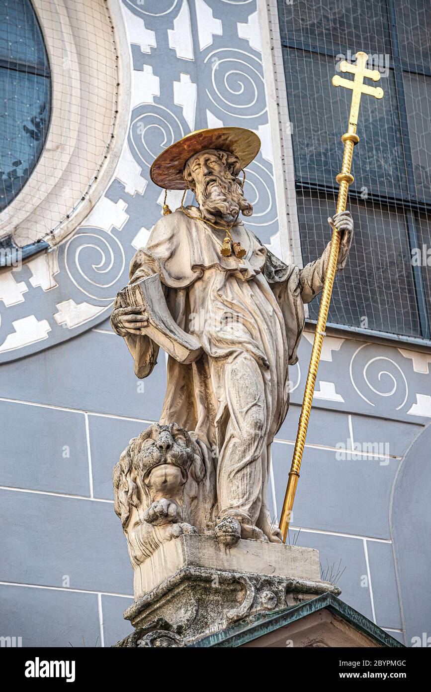 Statue of pilgrim priest with a cross, lion and book at the main facade ...