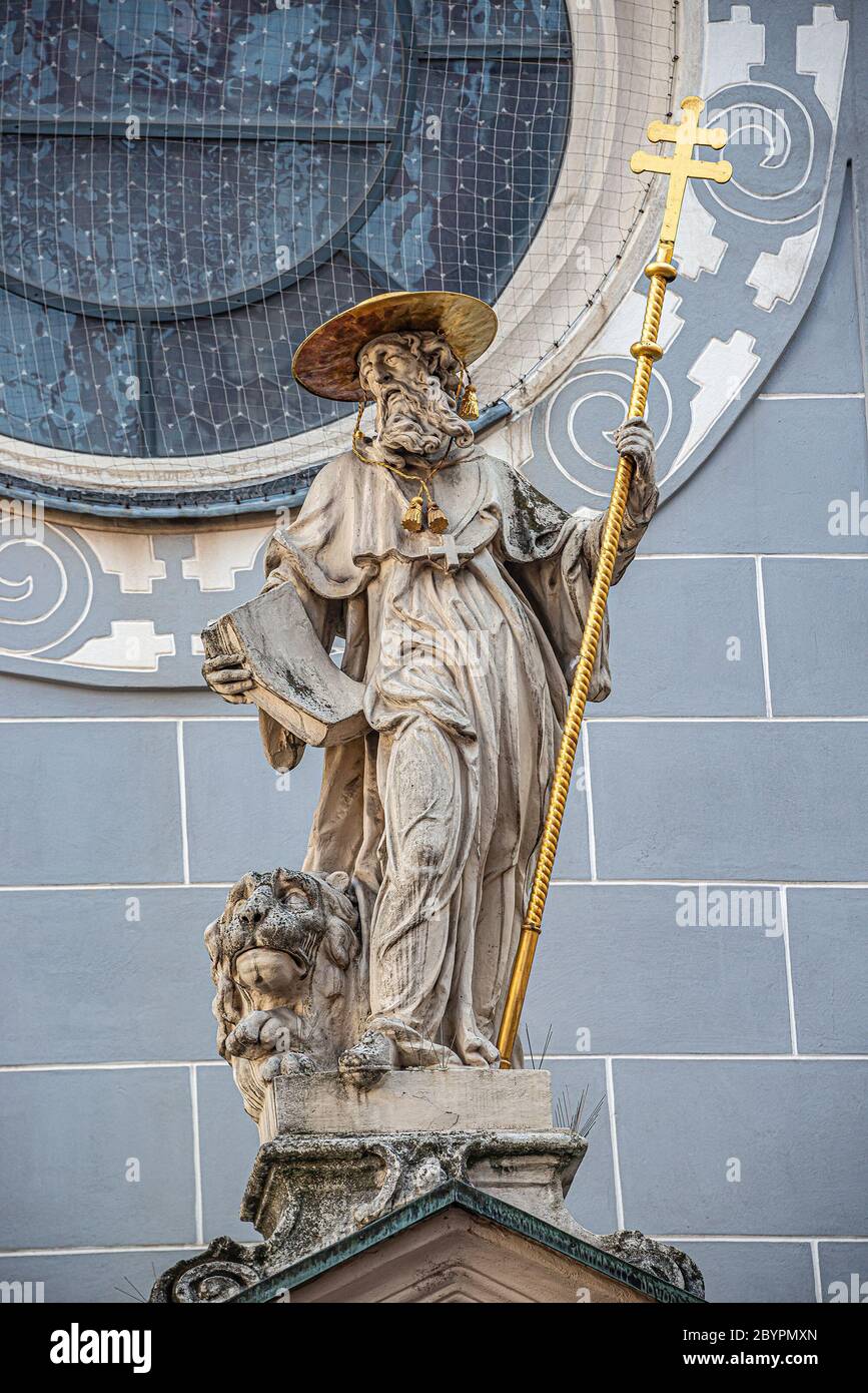 Statue of pilgrim priest with a cross, lion and book at the main facade ...