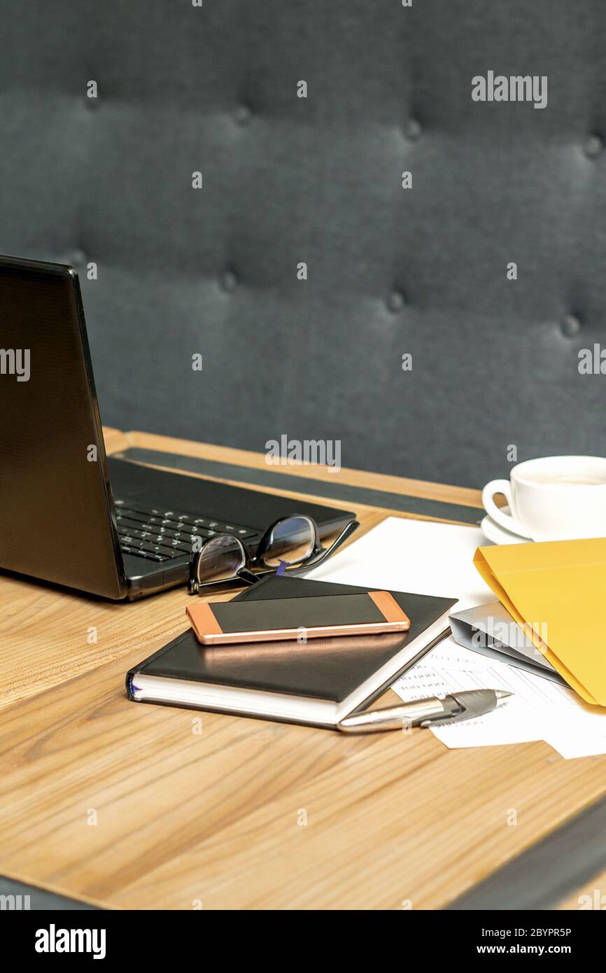 Office workplace with laptop, cup of coffee and paperwork without ...