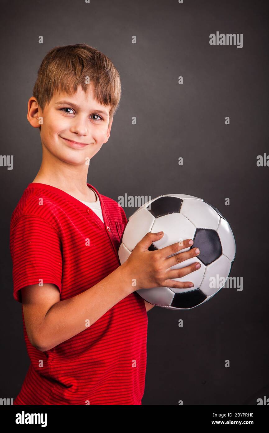 Cute boy is holding a football ball. Soccer ball Stock Photo - Alamy