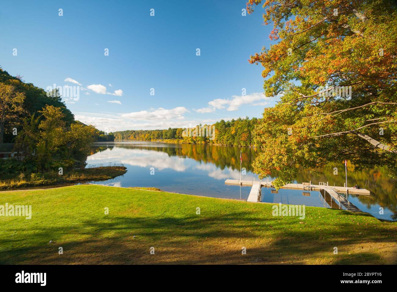 Beautiful Connecticut River lined by autumn foliage forest with jetty ...
