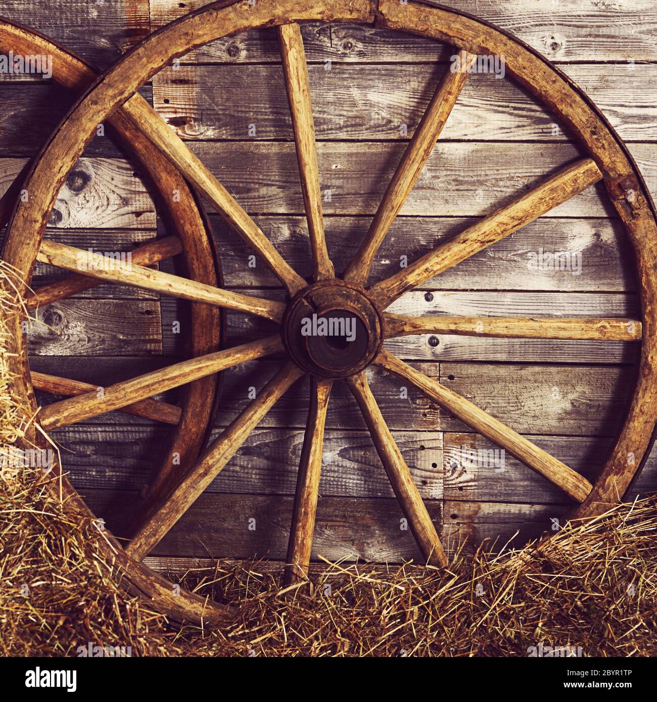 Old wooden wheel on a hay Stock Photo - Alamy