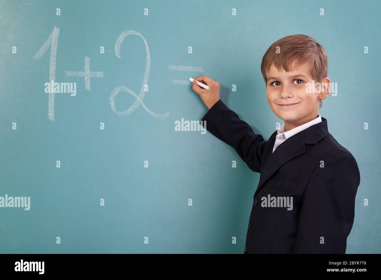 School student writing on blackboard at school Stock Photo - Alamy