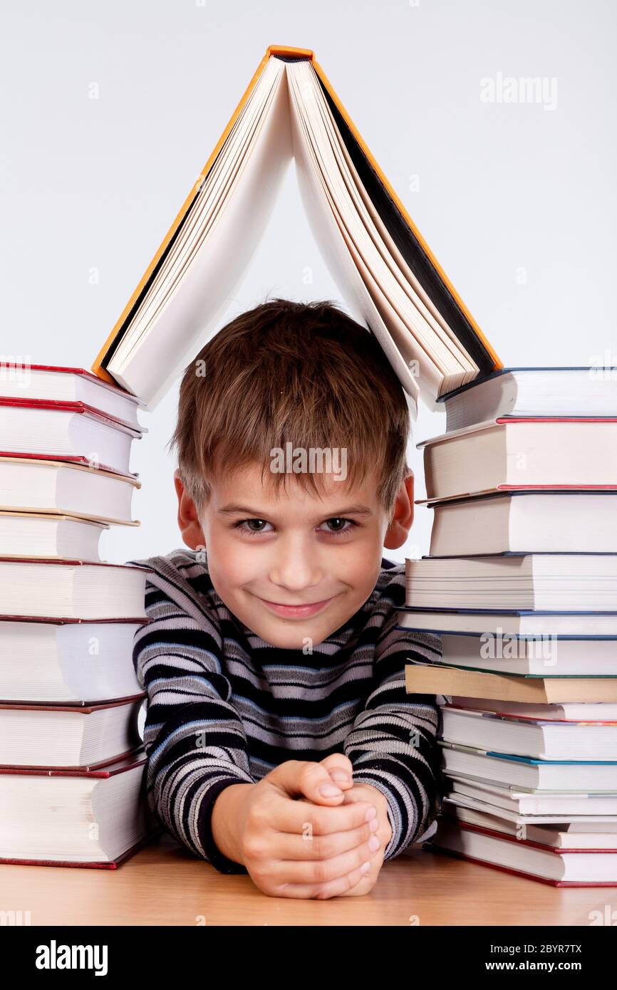 Schoolboy and a heap of books Stock Photo - Alamy