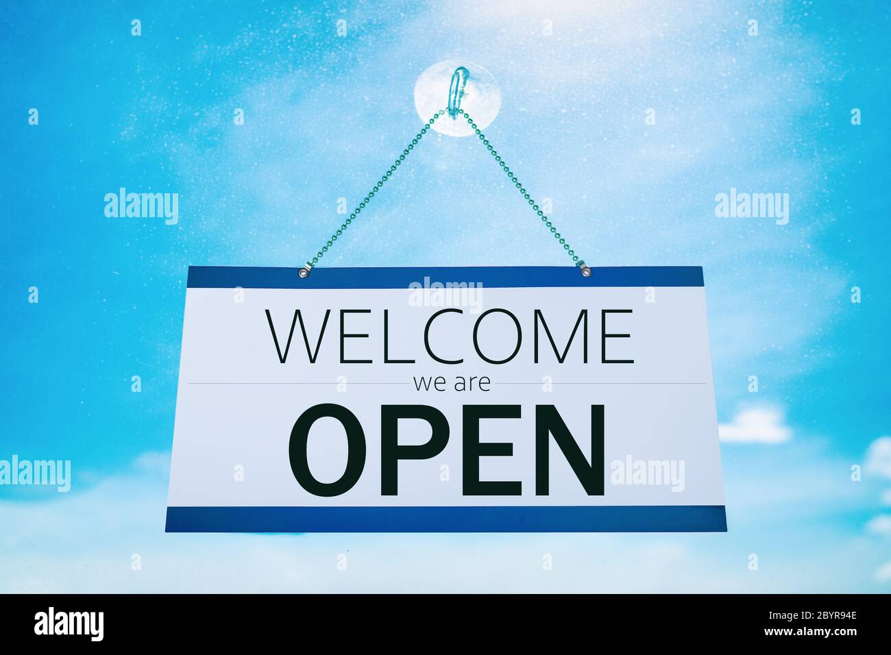 COVID-19 WELCOME we are Open for business hanging on store front window ...