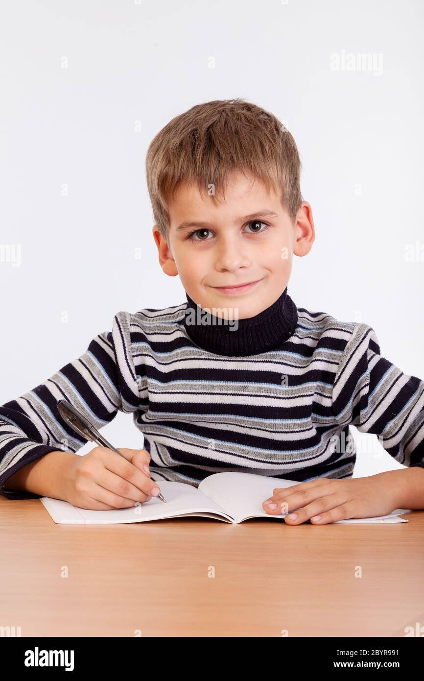 Cute schoolboy is writting Stock Photo - Alamy