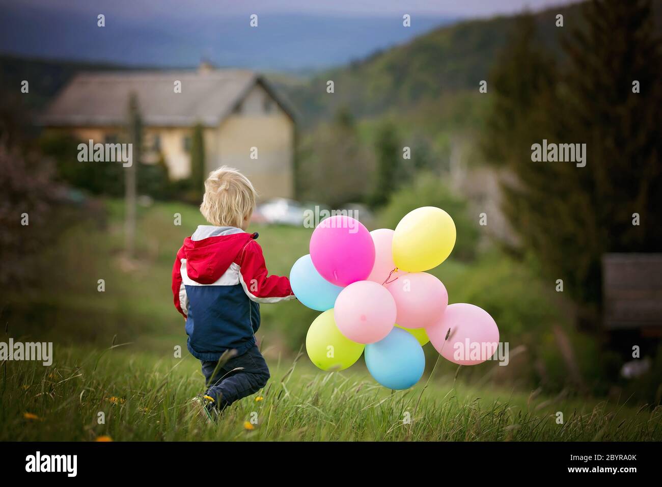 Little child, cute boy on a spring cold windy rainy day, holding ...