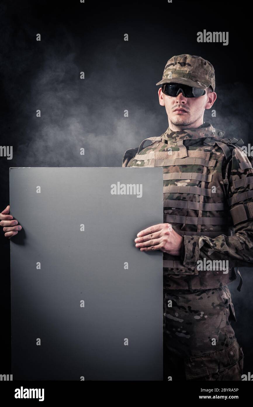 Modern soldier is holding a poster Stock Photo - Alamy