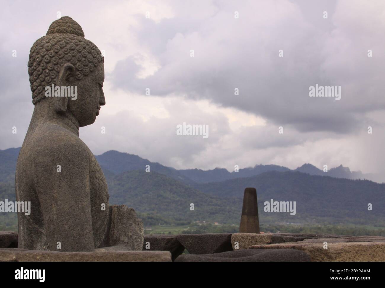Side view of buddha statue in stupa at Borobudur buddhist temple ...