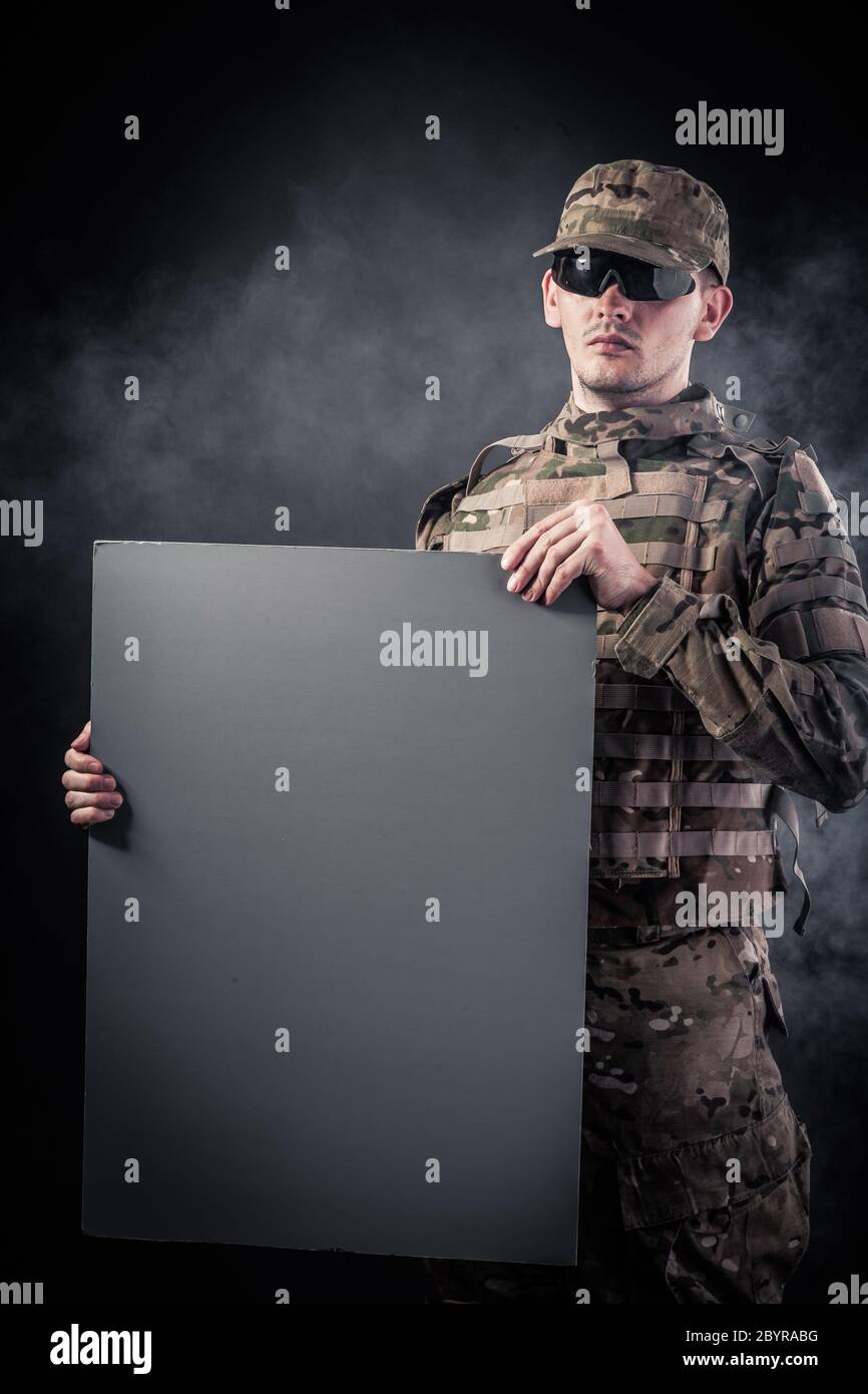 Modern soldier is holding a poster Stock Photo - Alamy