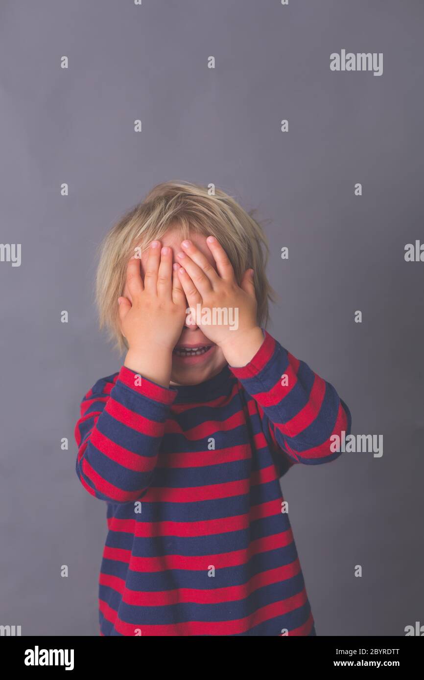 Little toddler child, boy, crying, hiding his face with hand, isolated ...