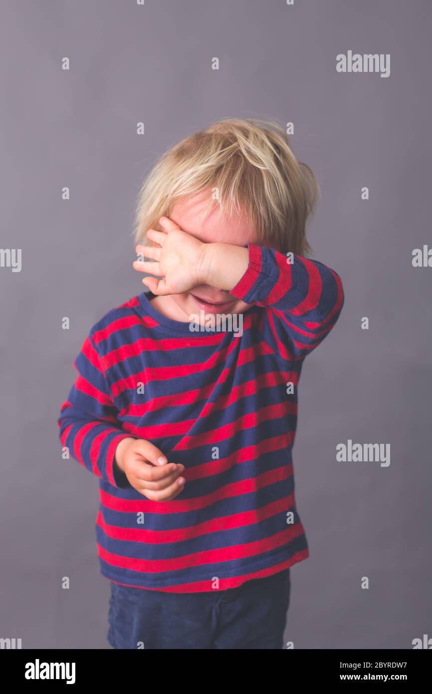 Little toddler child, boy, crying, hiding his face with hand, isolated ...