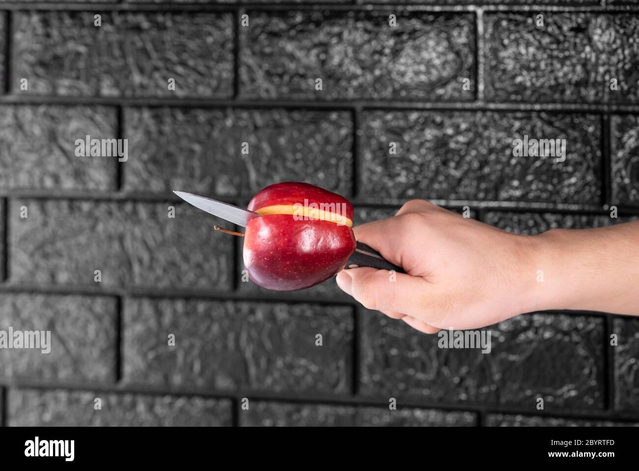 Red apple pierced by a stainless steel knife held by human hand Stock ...