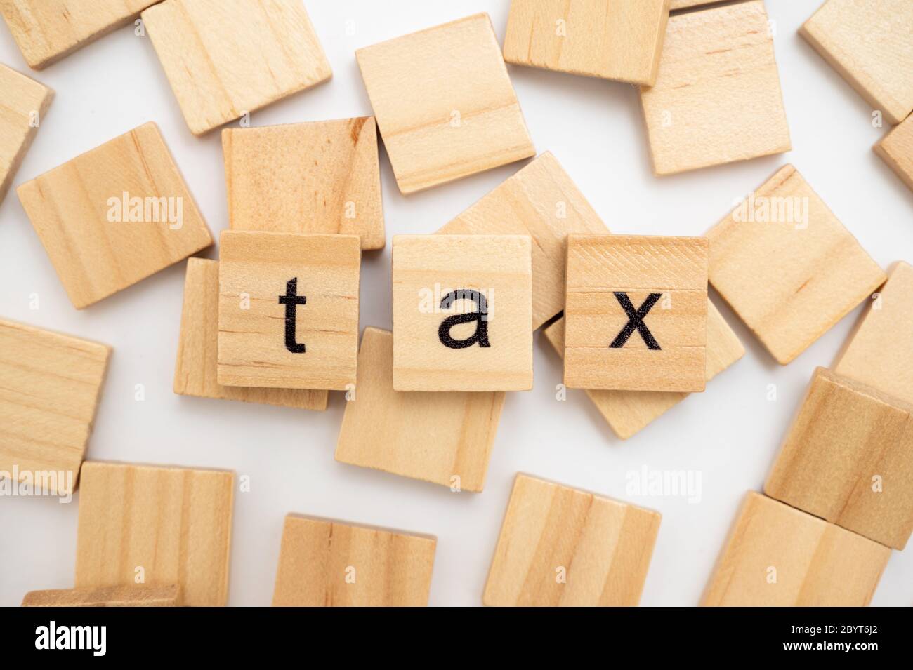 Wood letter tiles spelling word TAX isolated on a white background ...