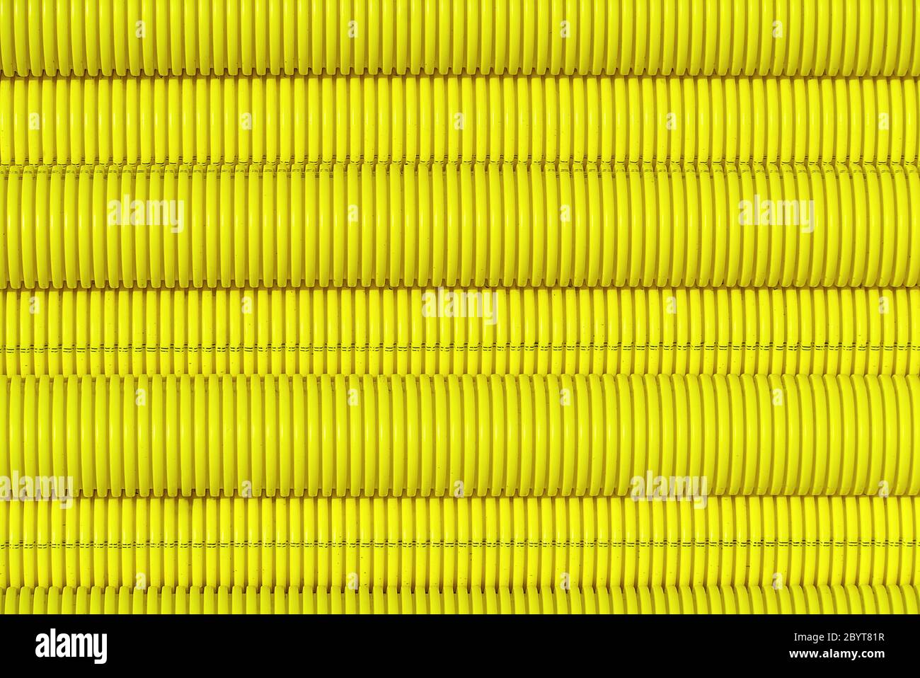 yellow plastic pipes for laying electricity cables underground. texture ...