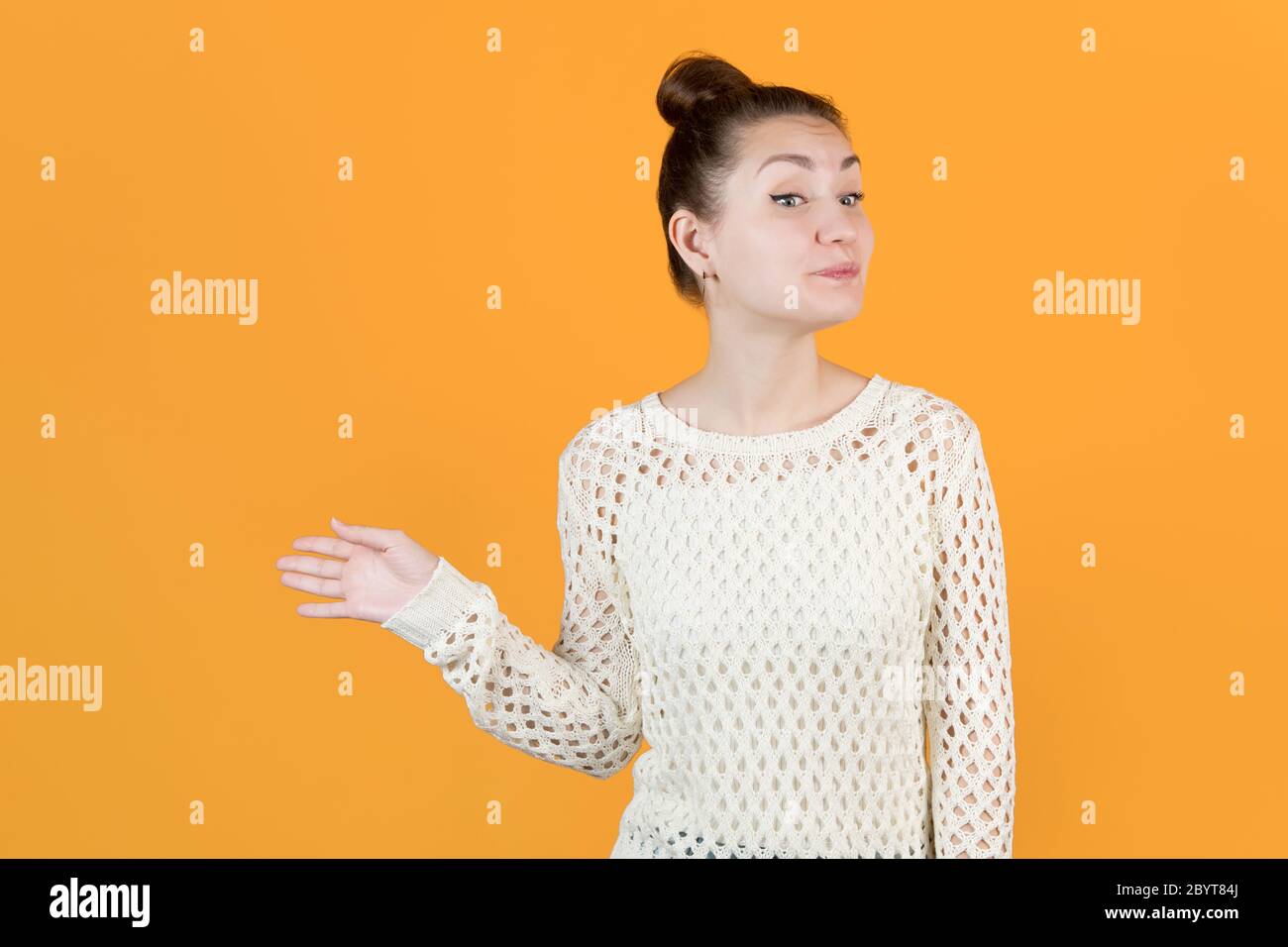 Young girl cunningly looks up, holding out her hand in the opposite ...