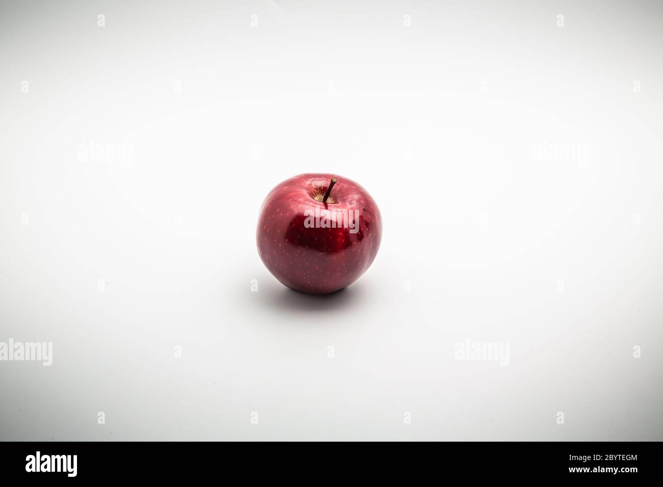 Close up shot of a red shiny dotted apple isolated on white background ...