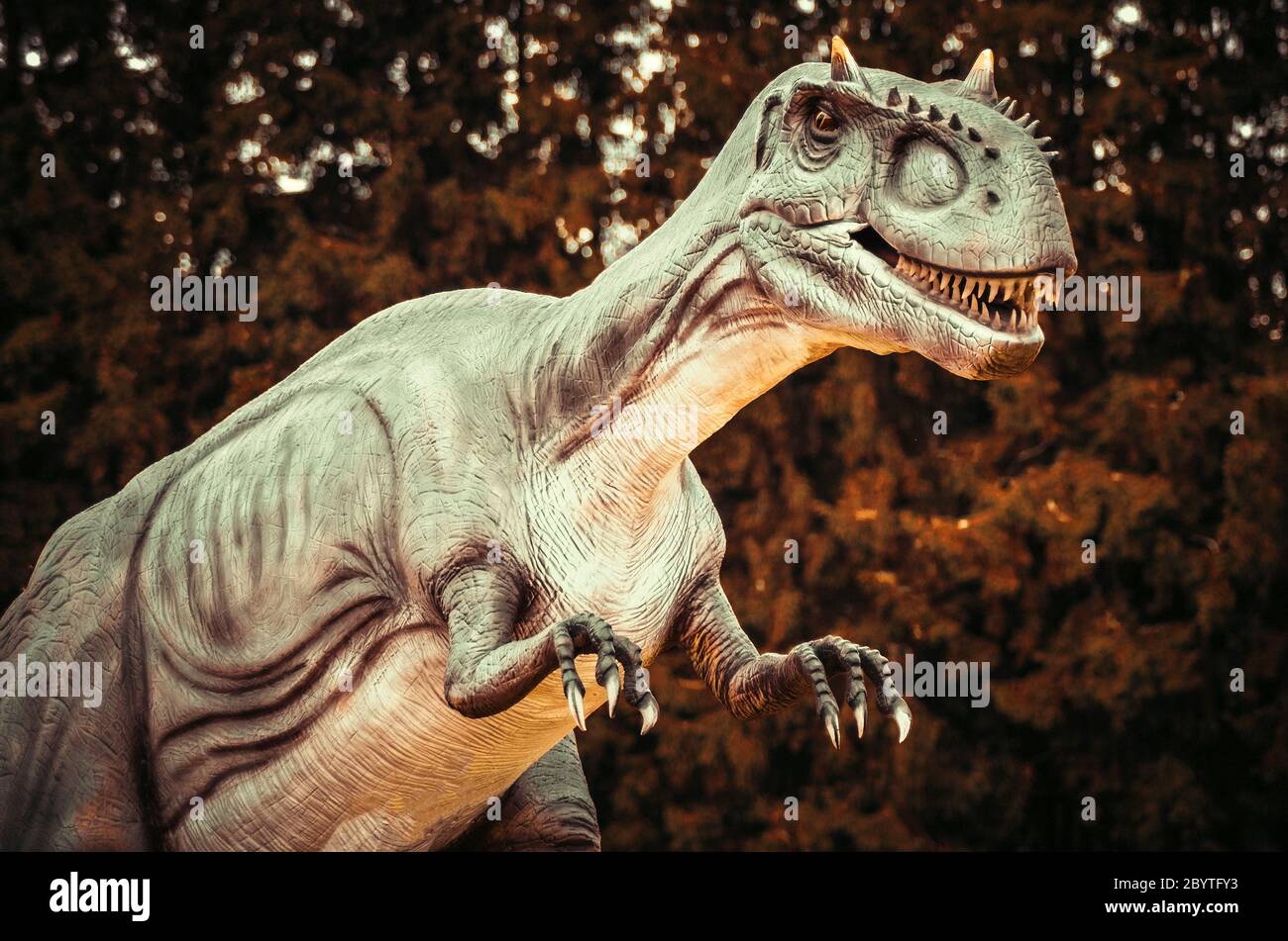 Realistic model of dinosaur in forest Stock Photo - Alamy