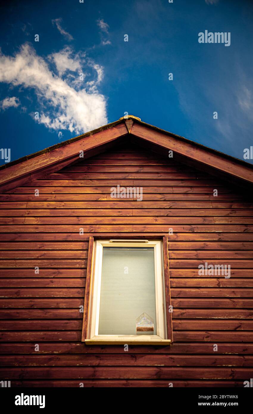 wooden hut with window and roof against blue sky and clouds Stock Photo ...