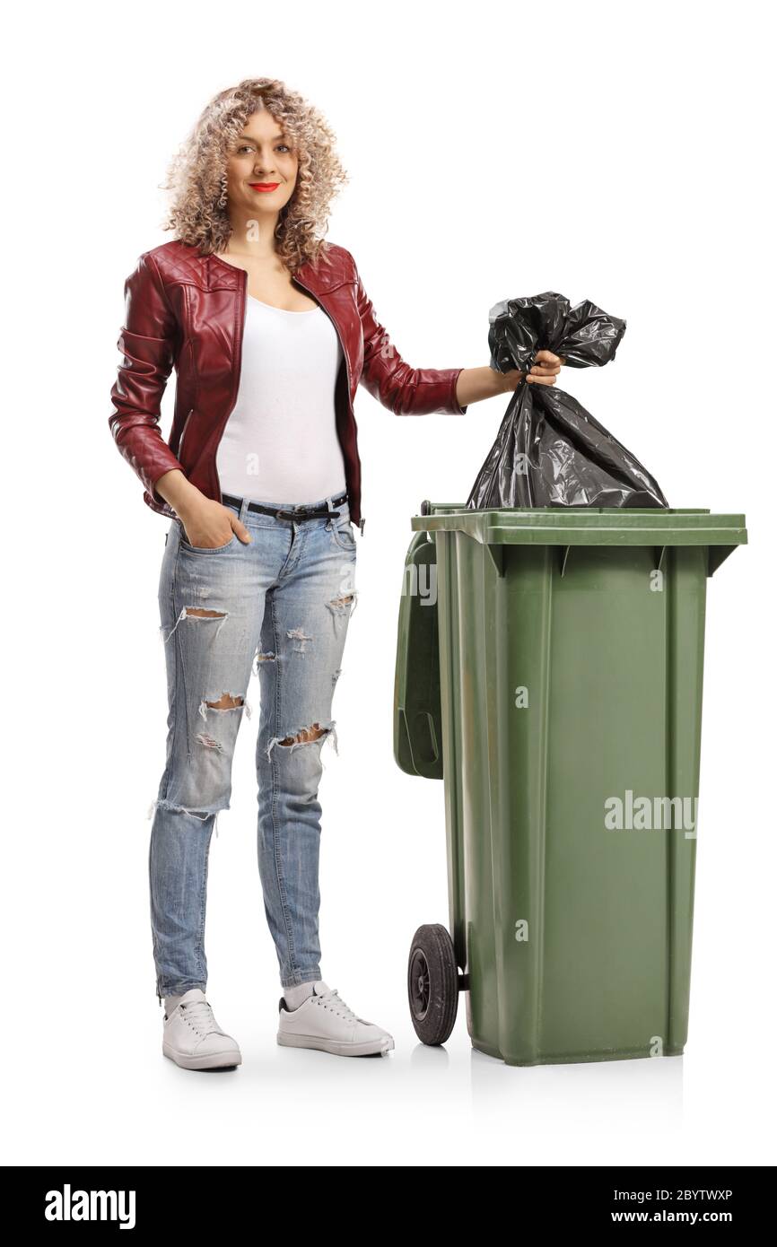 Full length portrait of a young woman throwing a waste bag in a garbage ...