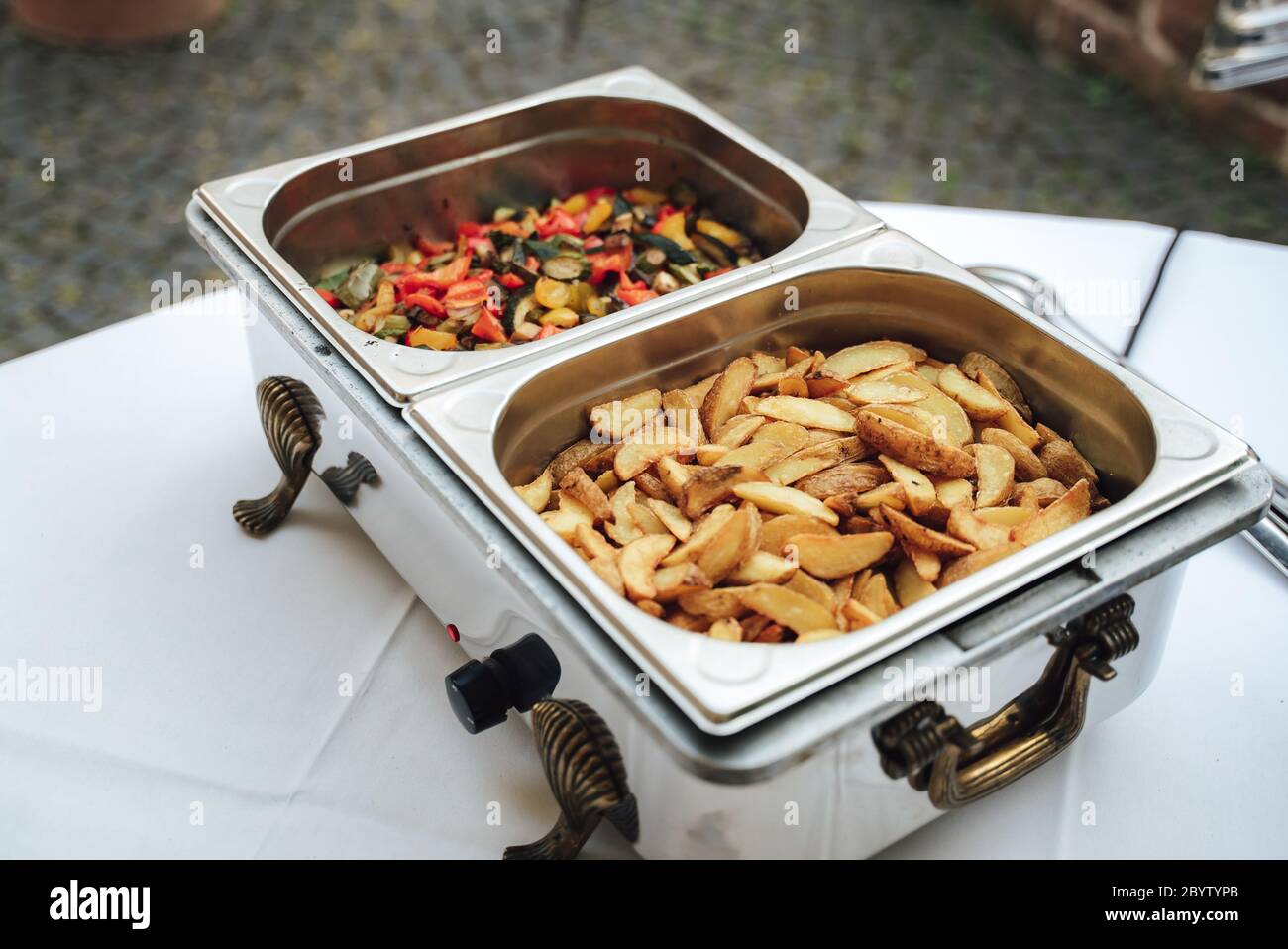 Fried american potatoes and mix of grilled vegetable in hotel pans on ...