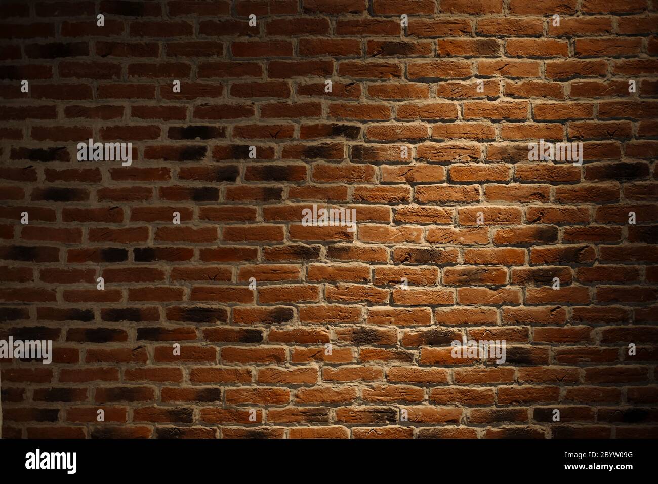 Texture of a brick wall with a light spot Stock Photo - Alamy