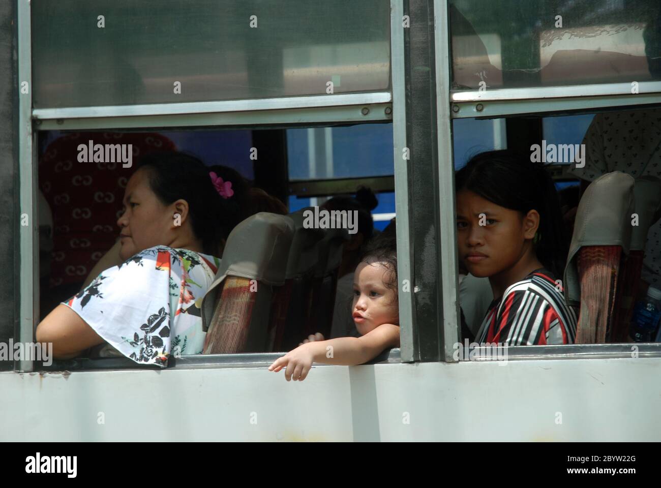 Child hanging out the window of a city bus in Manila, Philippines Stock ...
