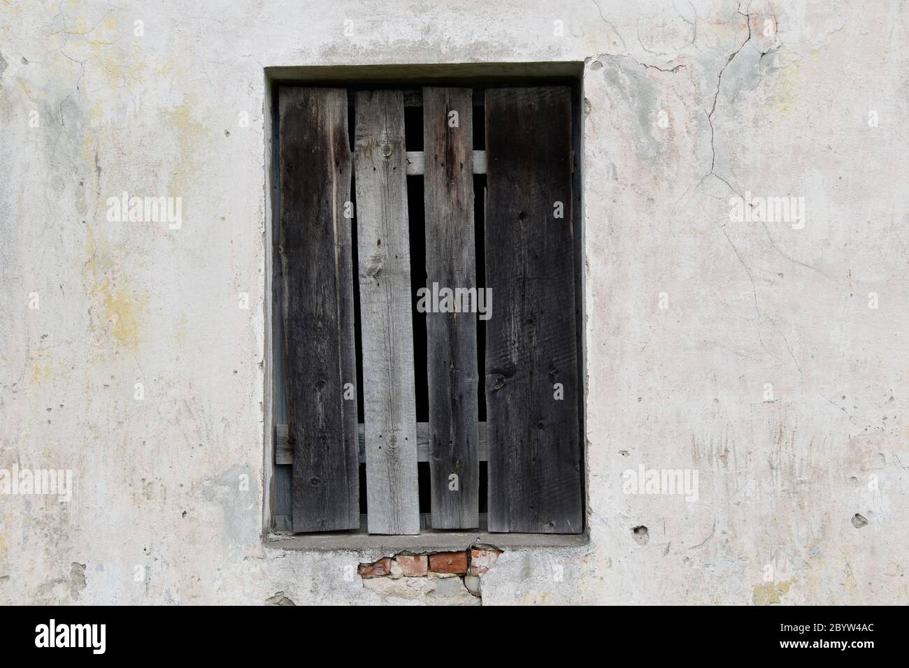 Boarded building window with burnt discolored planks Stock Photo - Alamy