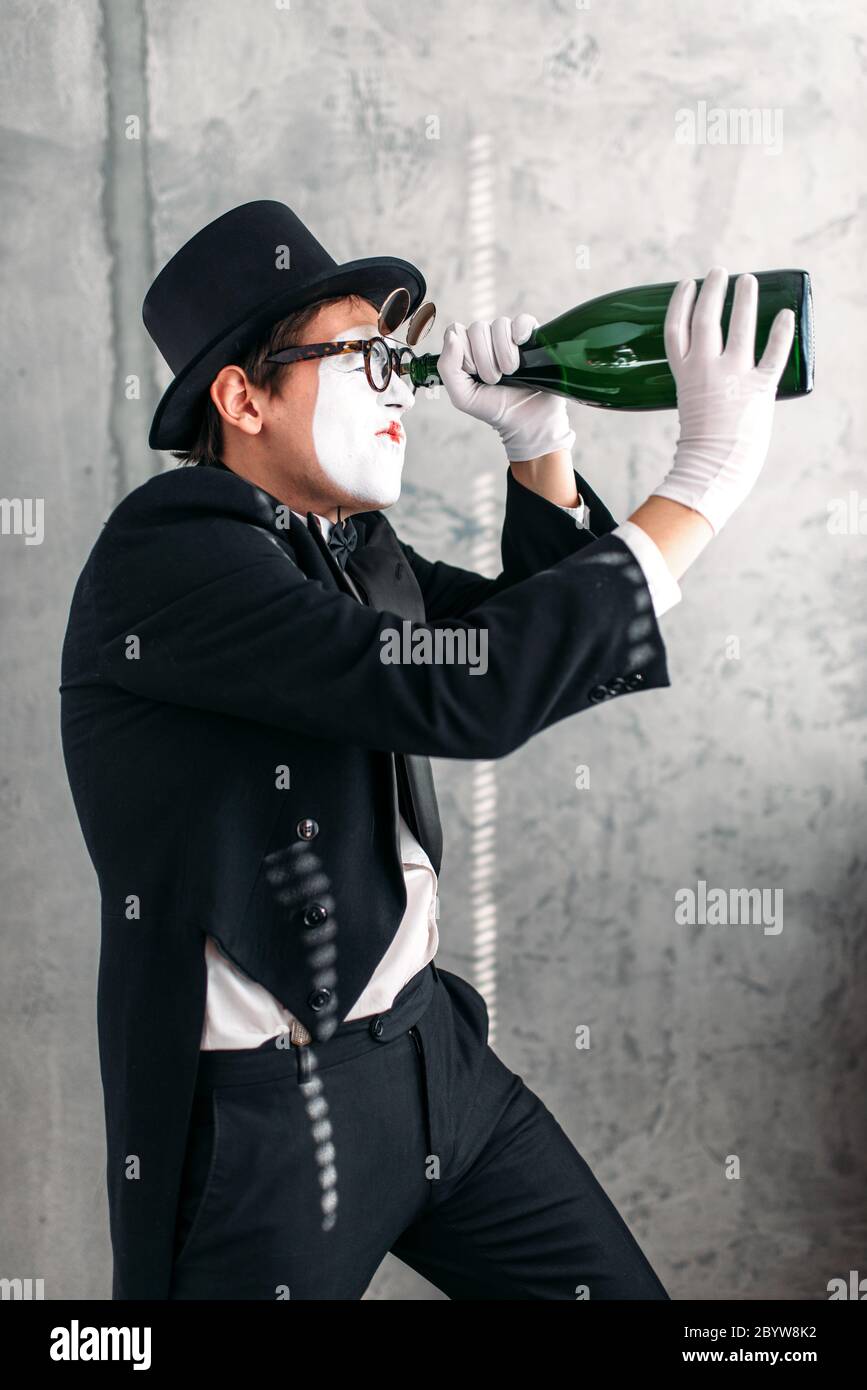 Pantomime theater actor performing with big bottle. Comedy mime artist ...