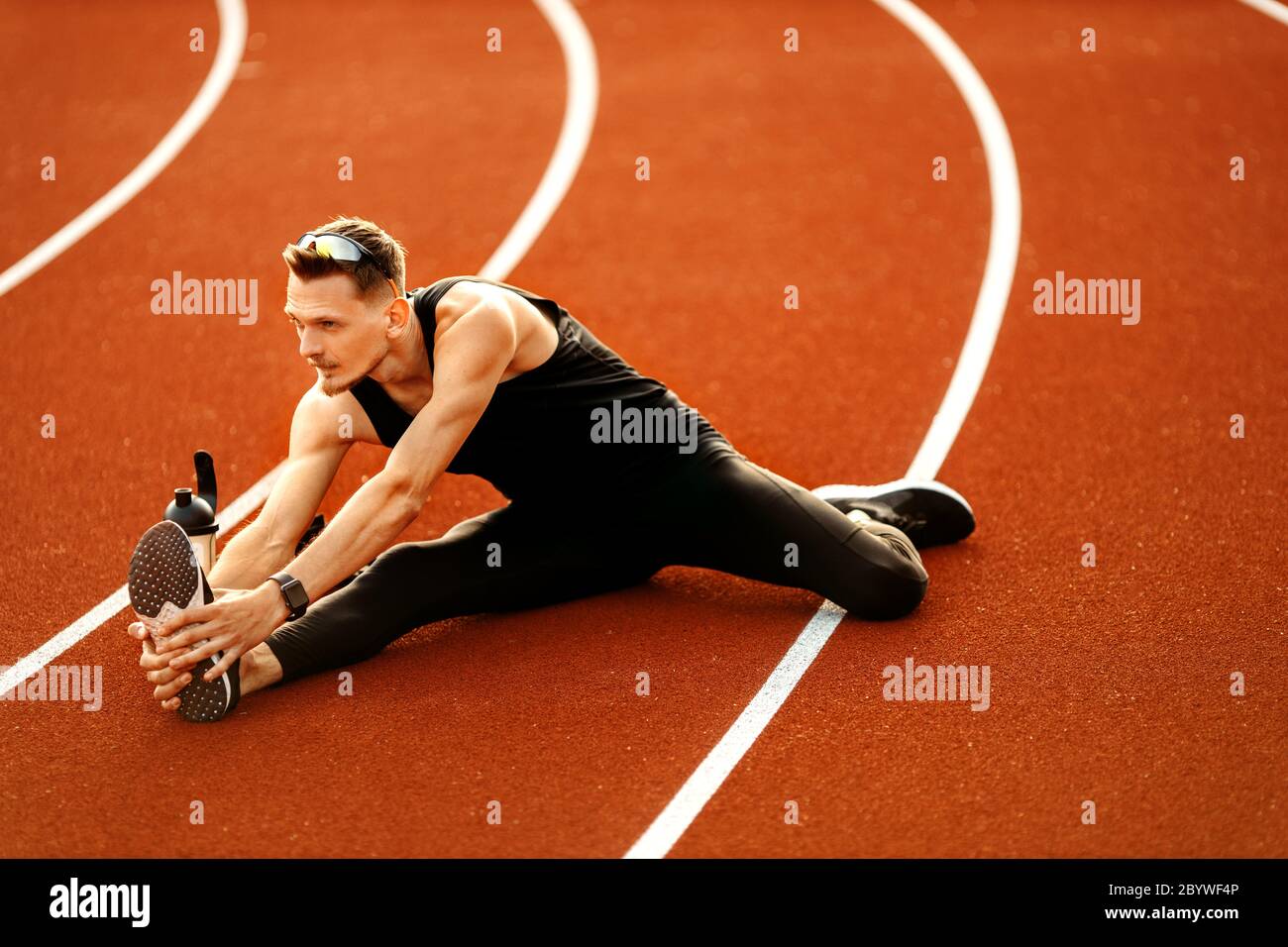 Young athlete resting after running in the stadium Stock Photo - Alamy