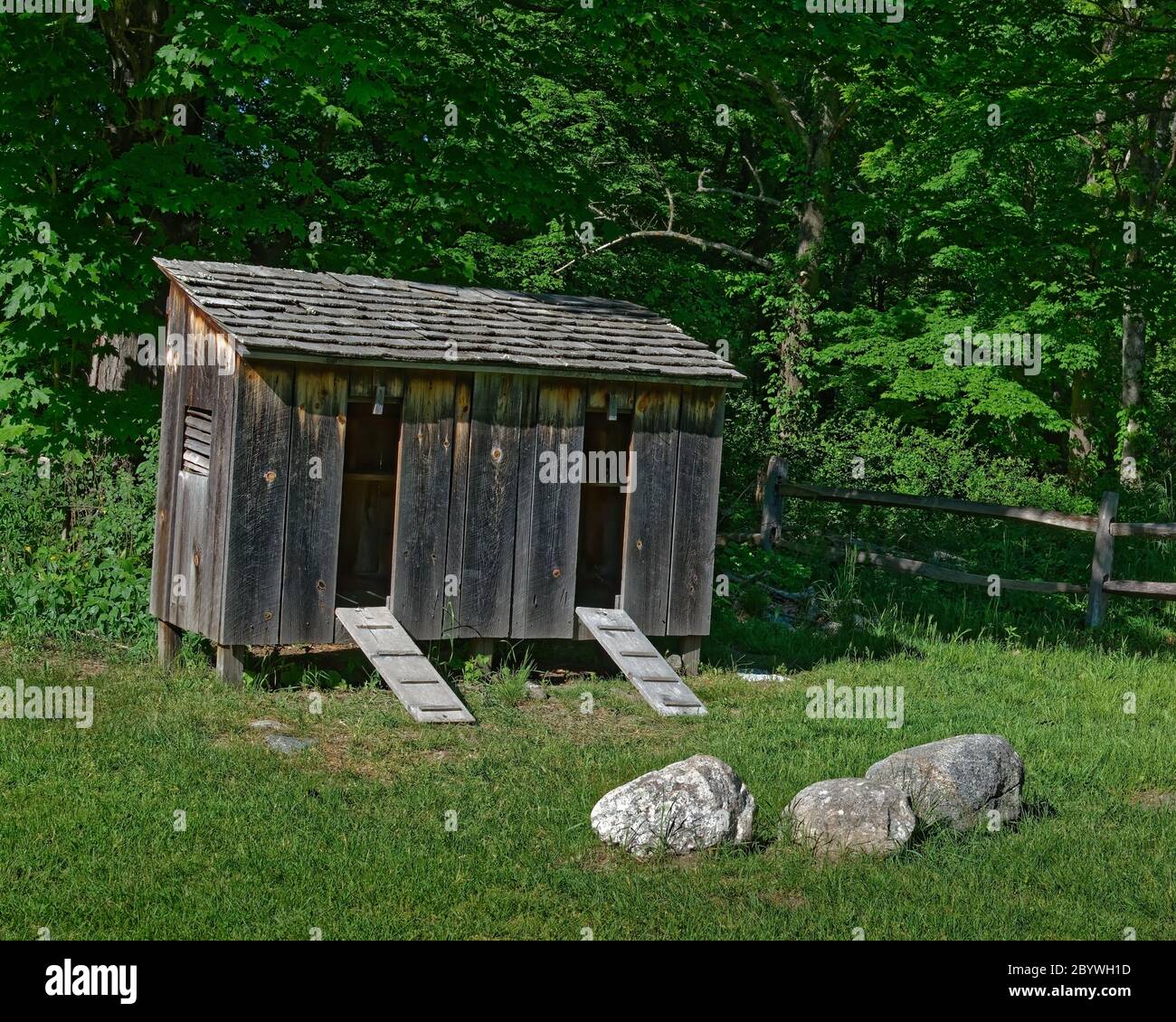 An 18th-century wood chickencoop sits empty illuminated by the setting ...