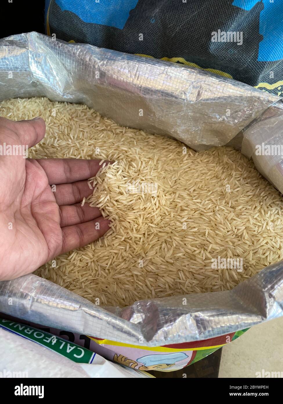 Men's hand picking uncooked rice in a small burlap sack. Top view Stock ...