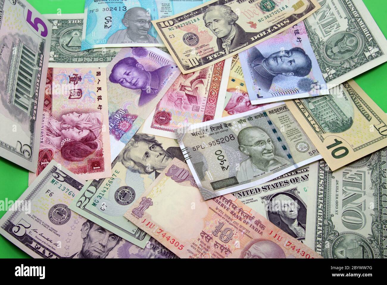 Mix of American, Chinese and Indian colorful banknotes in a bright ...