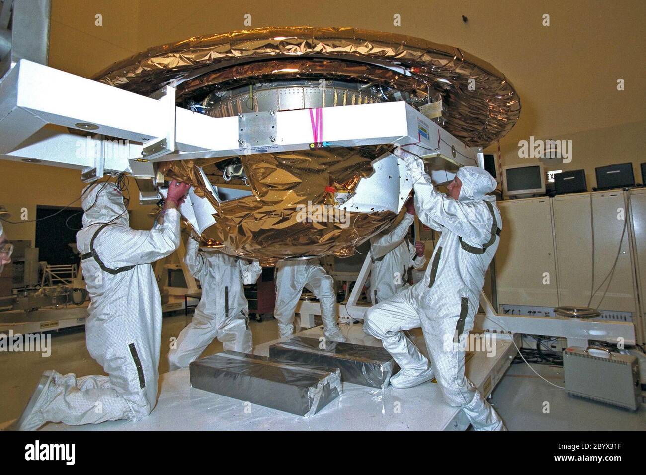 Dornier Satelliten Systeme (DSS) workers place the back cover of the ...