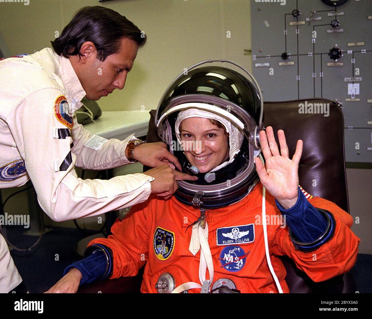 With the assistance of a suit technician, STS-84 Pilot Eileen Marie Collins finishes donning her ...