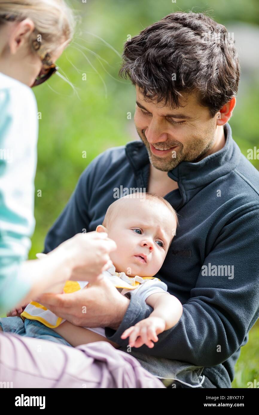 Mom and dad caring for baby Stock Photo - Alamy