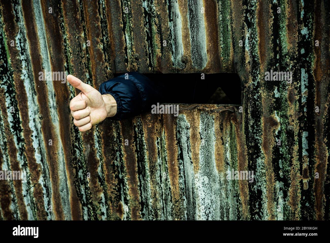 Thumb up shown by a person captive in prison Stock Photo - Alamy