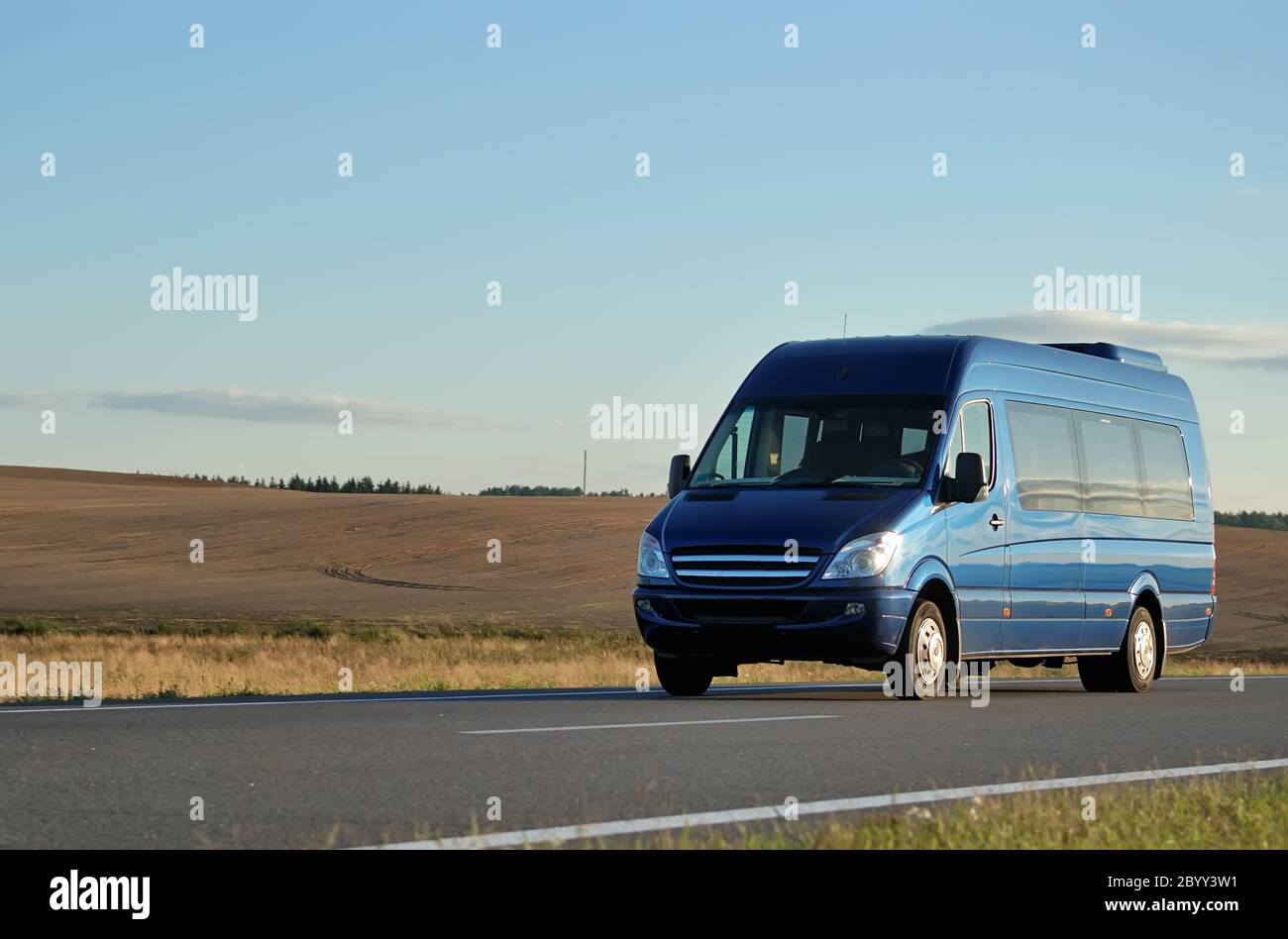 Blue minibus on highway Stock Photo - Alamy