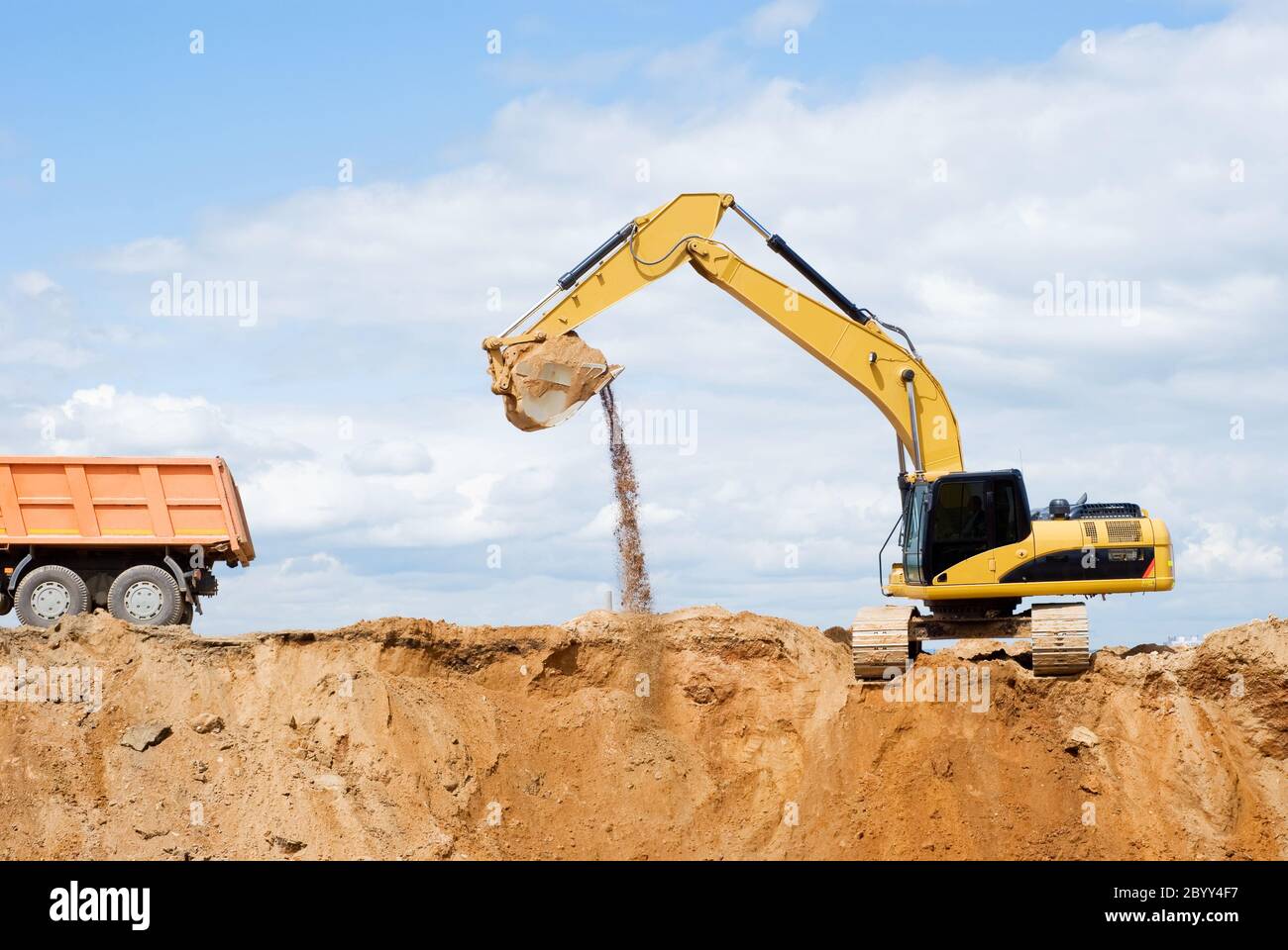 Excavator loading dumper truck Stock Photo - Alamy
