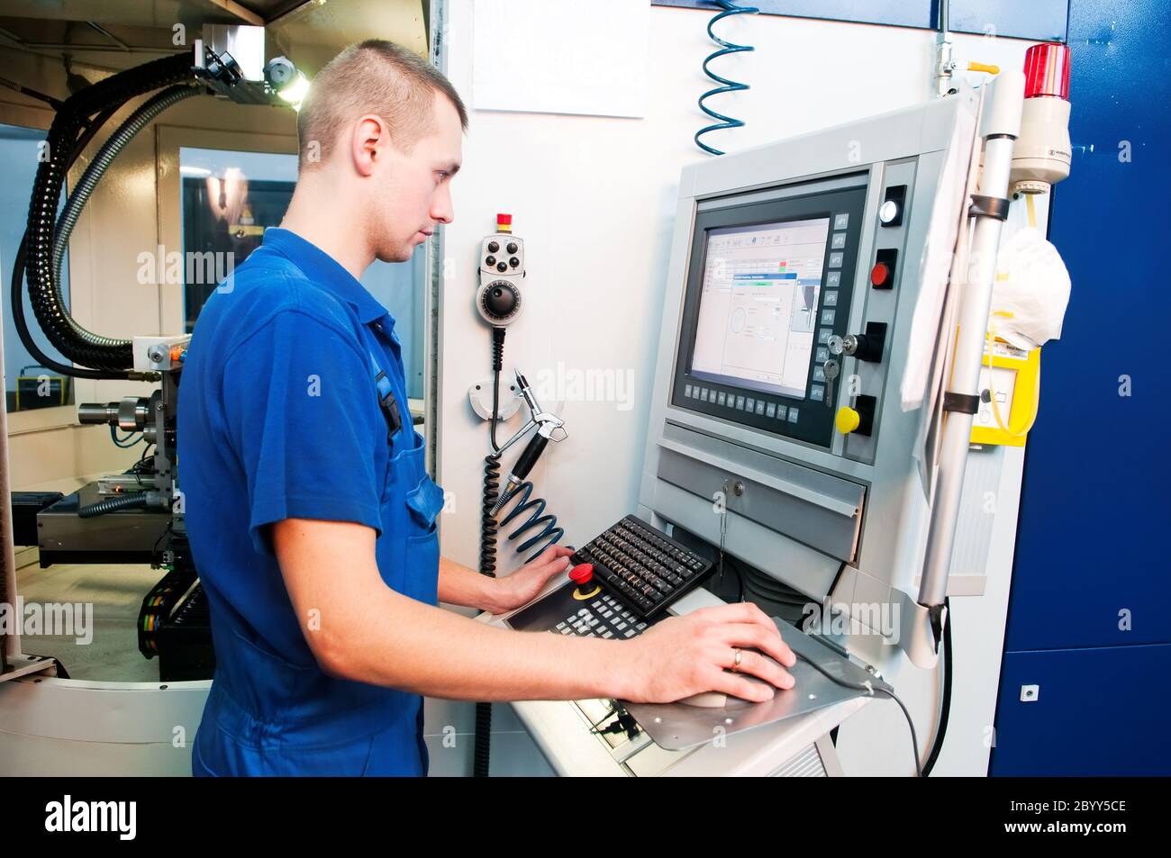 worker operating CNC machine center Stock Photo - Alamy