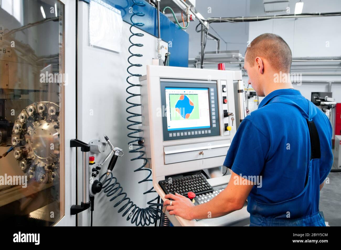 worker operating CNC machine center Stock Photo - Alamy