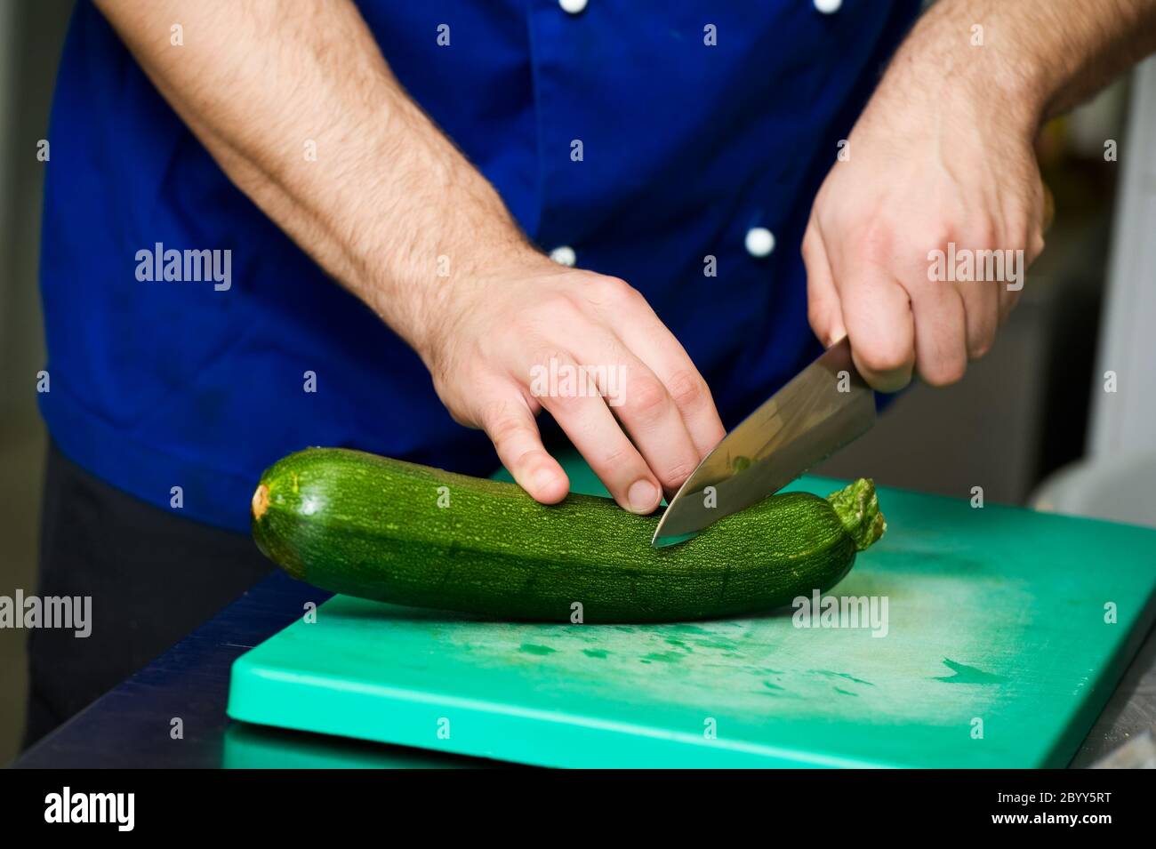 cutting green marrow on board Stock Photo - Alamy