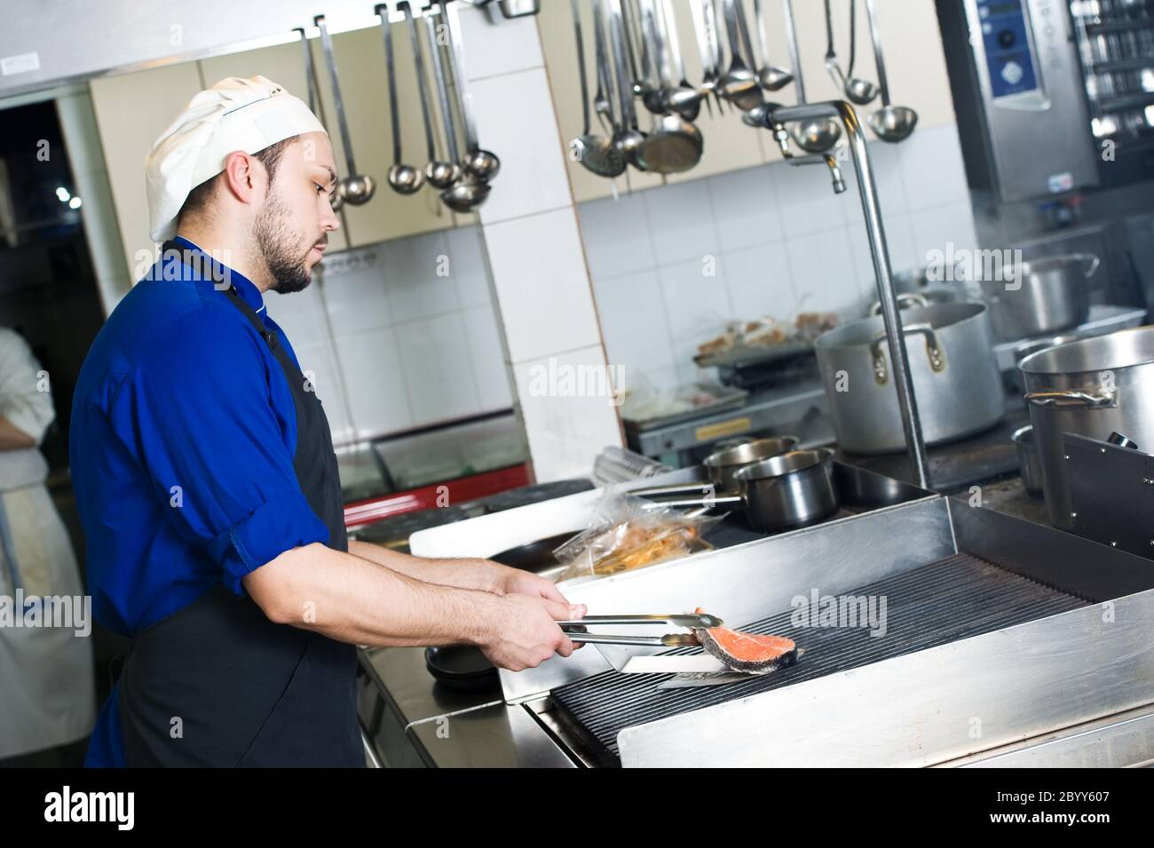 chef frying a fish on grill Stock Photo - Alamy