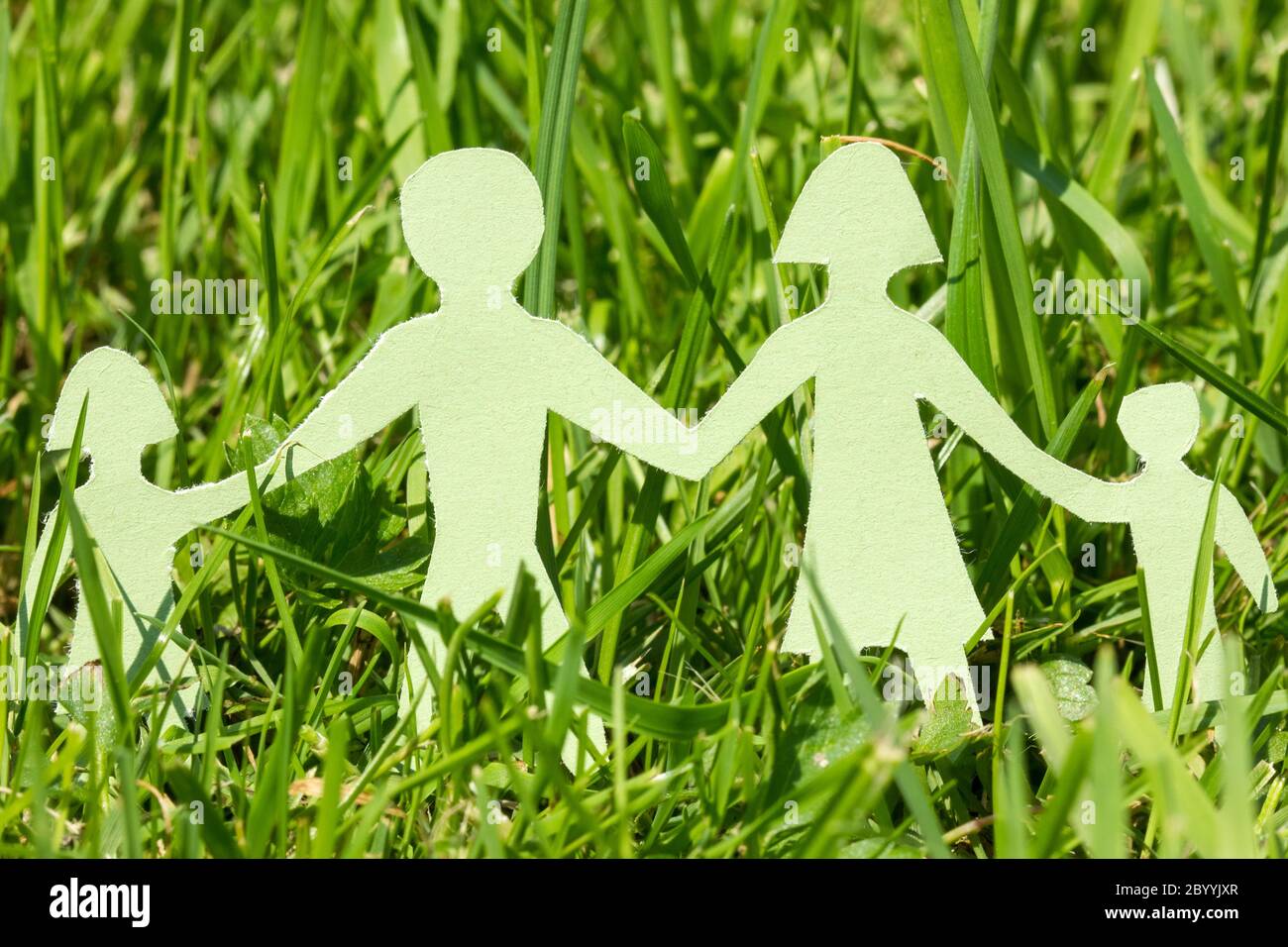 Paper family on a green grass Stock Photo - Alamy
