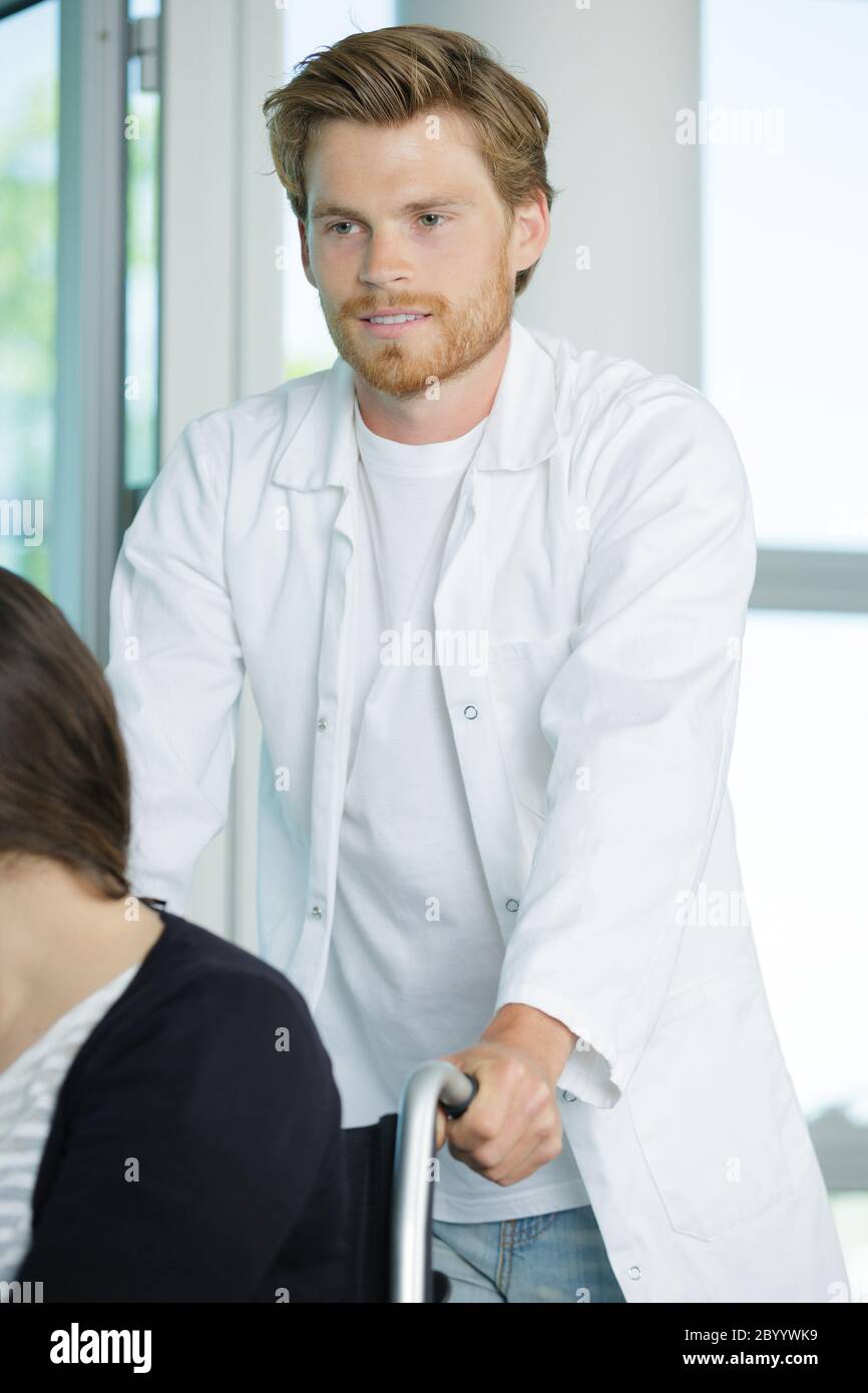 male nurse pushing patient in wheelchair in hospital Stock Photo - Alamy
